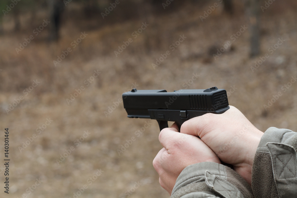 Shooting from a pistol. Reloading the gun. The man is aiming at the ...