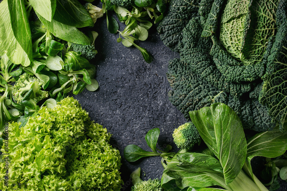 Variety of raw green vegetables salads, lettuce, bok choy, corn ...