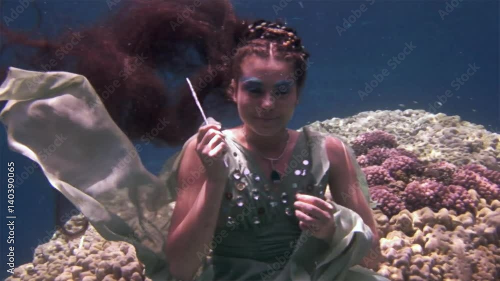 Underwater model free diver in fairy costume on background of corals in ...
