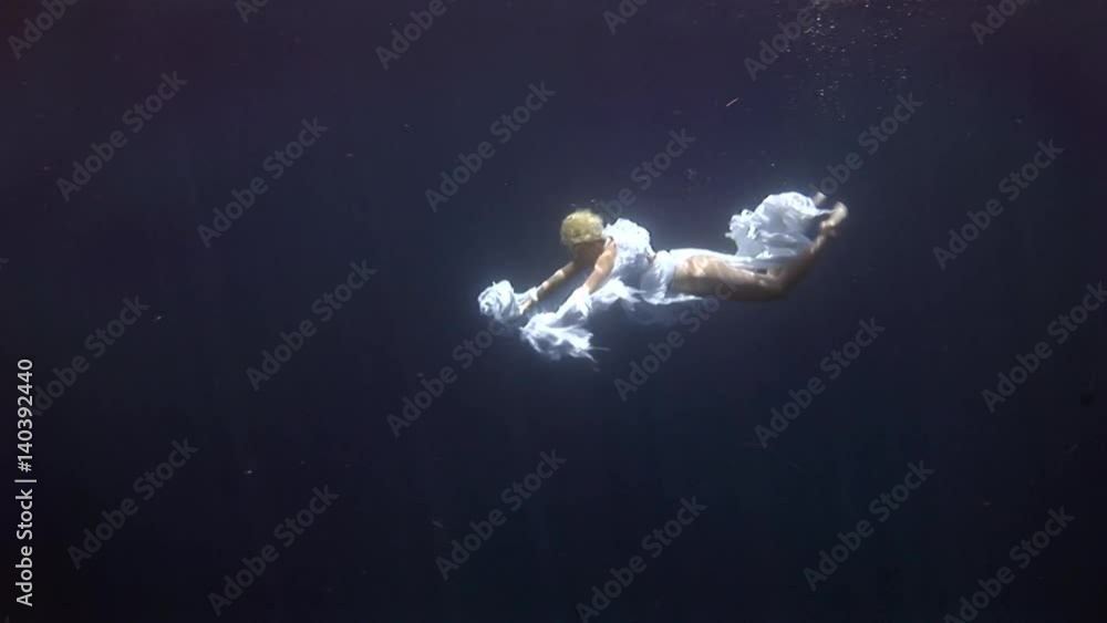 Young girl model free diver underwater white angel costume poses in Red ...