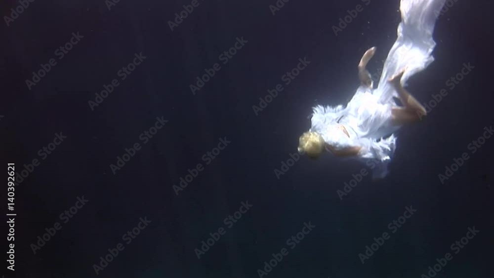 Young girl model free diver underwater white angel costume poses in Red ...