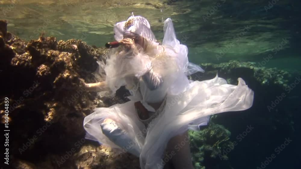Underwater model free diver in costume pirate swims in clean water in ...