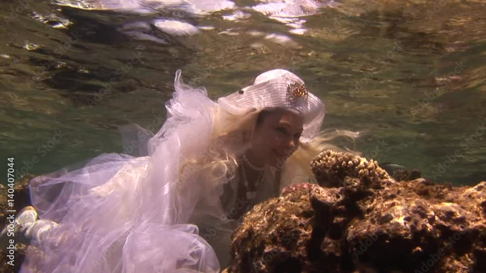 Underwater model free diver in costume pirate swims in clean water in ...