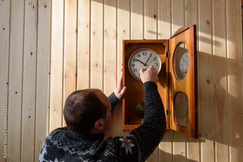 Mechanical clock in a wooden case. The man moves the arrows. Stock ...