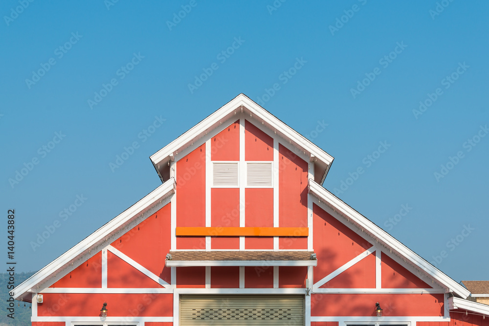 The beautiful gable roof of wooden red house with blue sky background ...