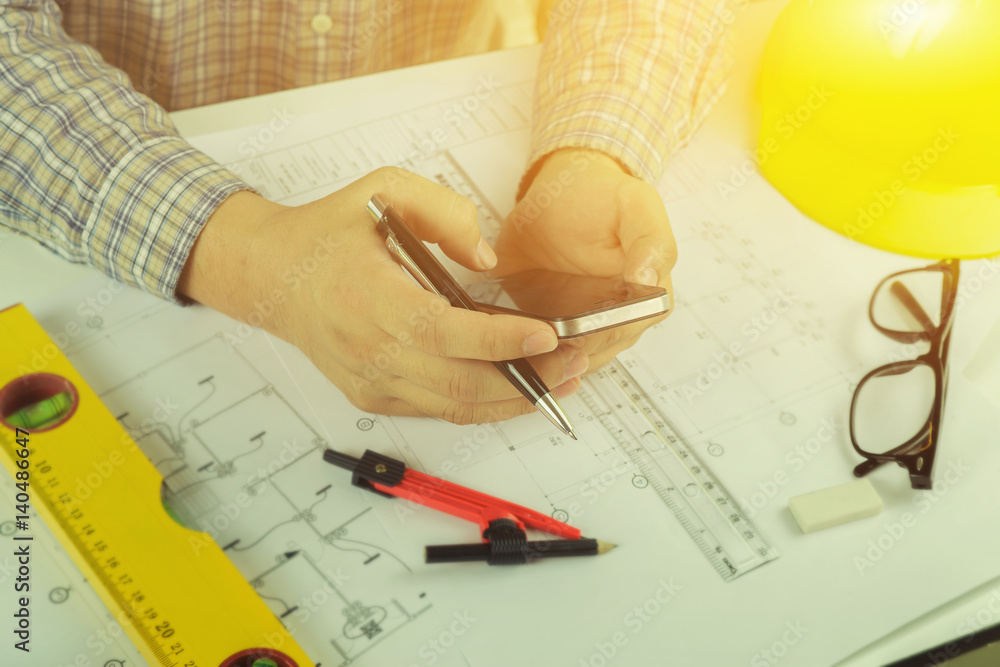 engineering using phone on his workspace,smart phone and plane ...