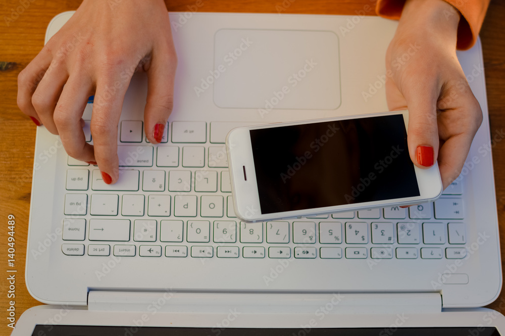 Woman hands working using computer and mobile phone. Closeup view of ...