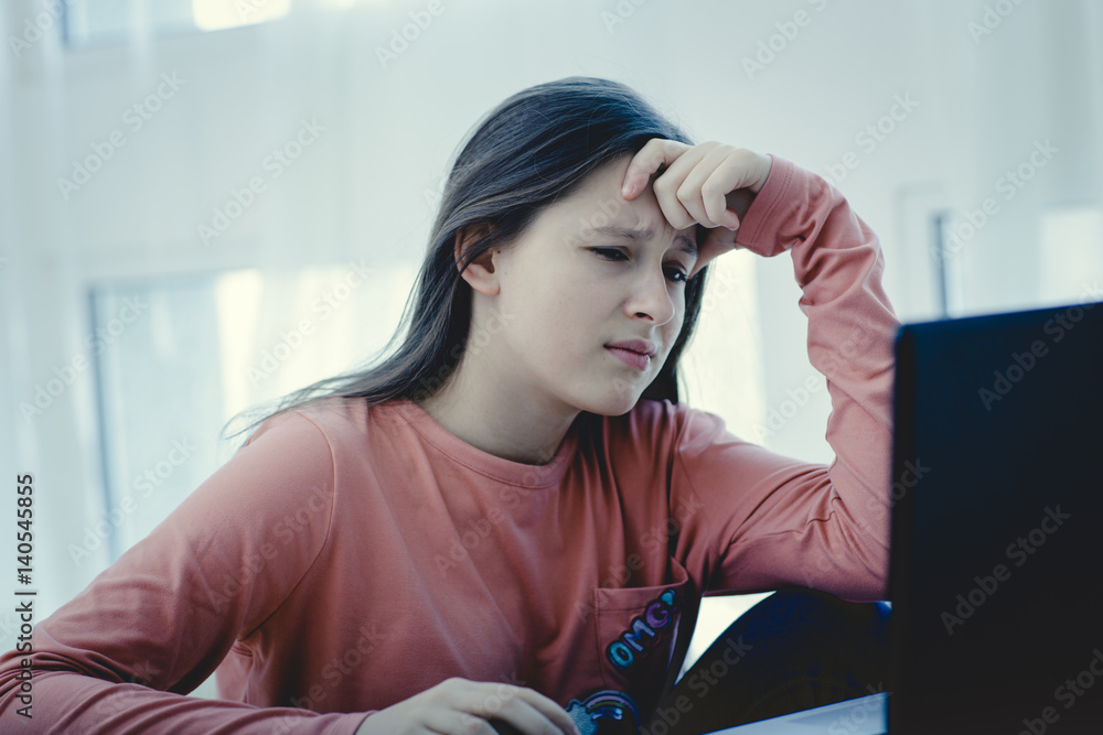 sad and scared female teenager with computer laptop suffering ...