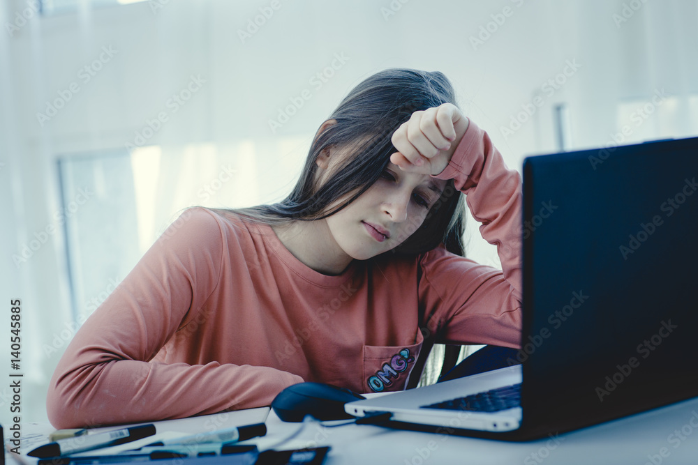 sad and scared female teenager with computer laptop suffering ...
