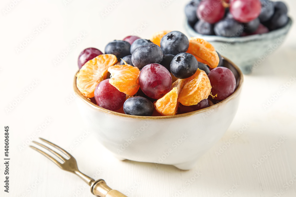 Plate with fruit salad of mandarin, grape, blueberry. Delicious and ...