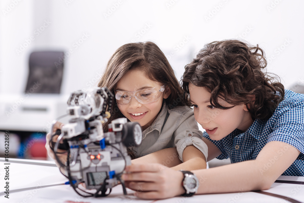 Curious kids playing with robot at school Stock Photo | Adobe Stock
