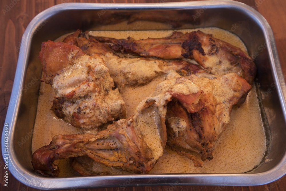 Roasted or baked rabbit meat in dijon mustard sauce in the shallow ...