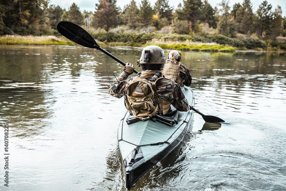Special forces men with painted faces in camouflage uniforms paddling ...