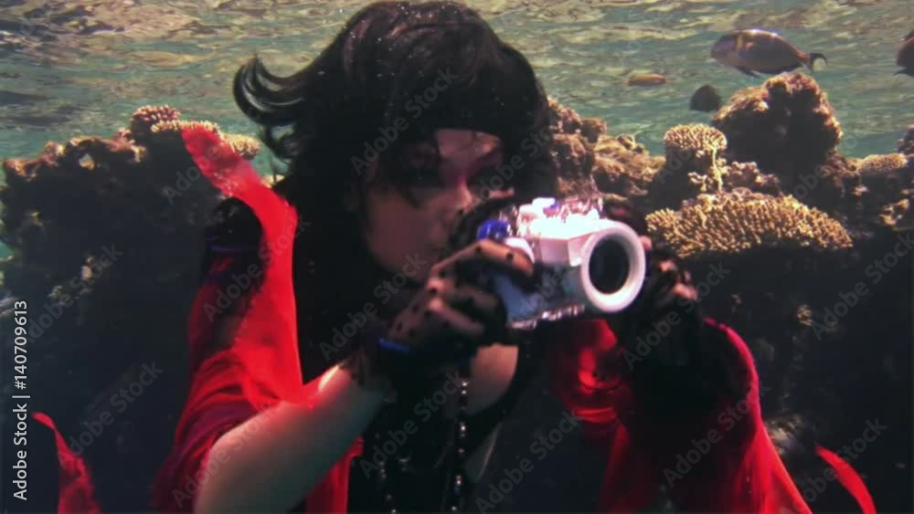 Young girl model free diver underwater in red costume of pirate in Red ...