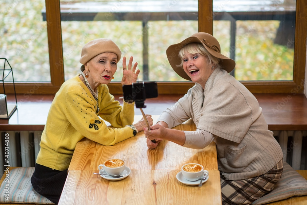 Senior ladies taking selfie. Elderly women beside cafe window. How to ...