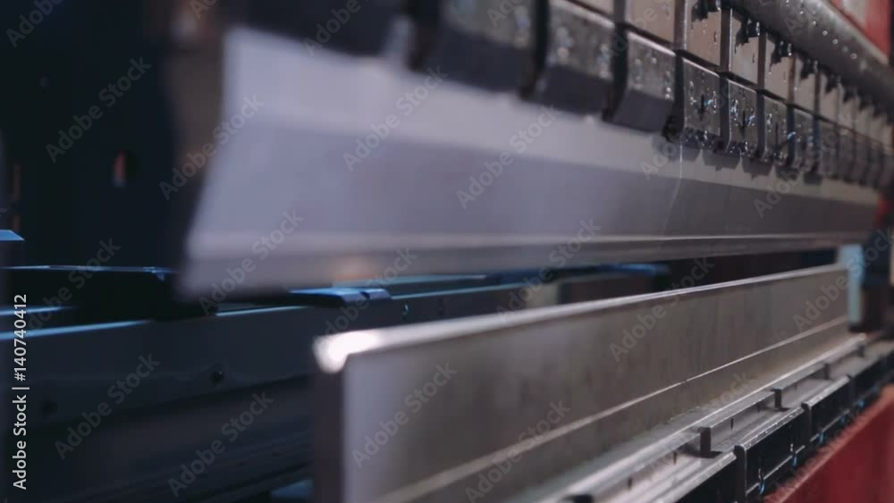 Pressing sheet metal on a machine tool factory. Worker puts the steel ...