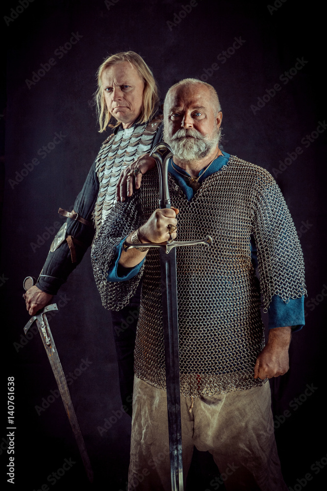 Two powerful knights with the swords on the dark background Stock Photo ...