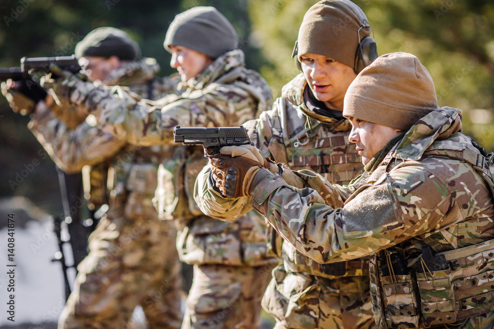 Instructor with operator aiming machine gun at firing range. People and ...