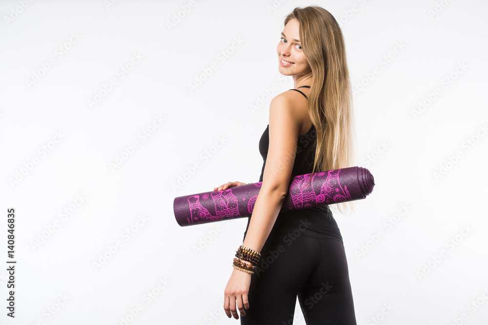 Back view portrait of a young fitness woman with yoga mat over white ...