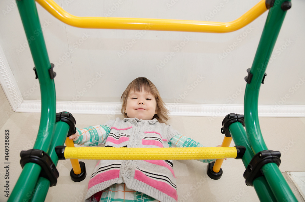 Children home workout. Little girl on gymnastic bar. Child health care ...