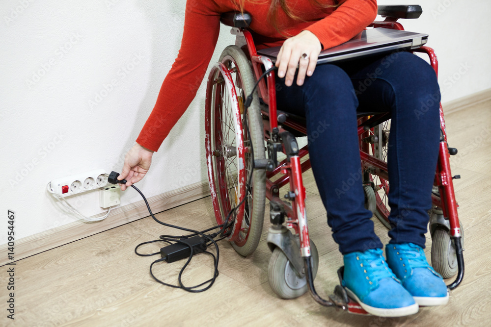 Caucasian female hand stretching to power socket in wall. Disabled ...