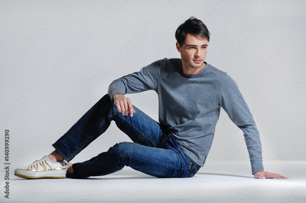 Handsome man sitting on the floor Stock Photo | Adobe Stock