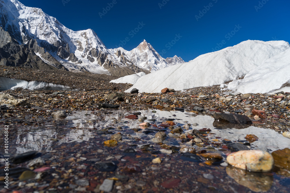 Ice on Baltoro glacier with Masherbrum nountain background, K2 trek ...