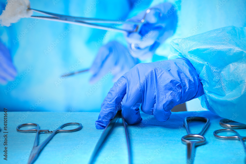 Close-up of of surgeons hands at work in operating theater toned in ...