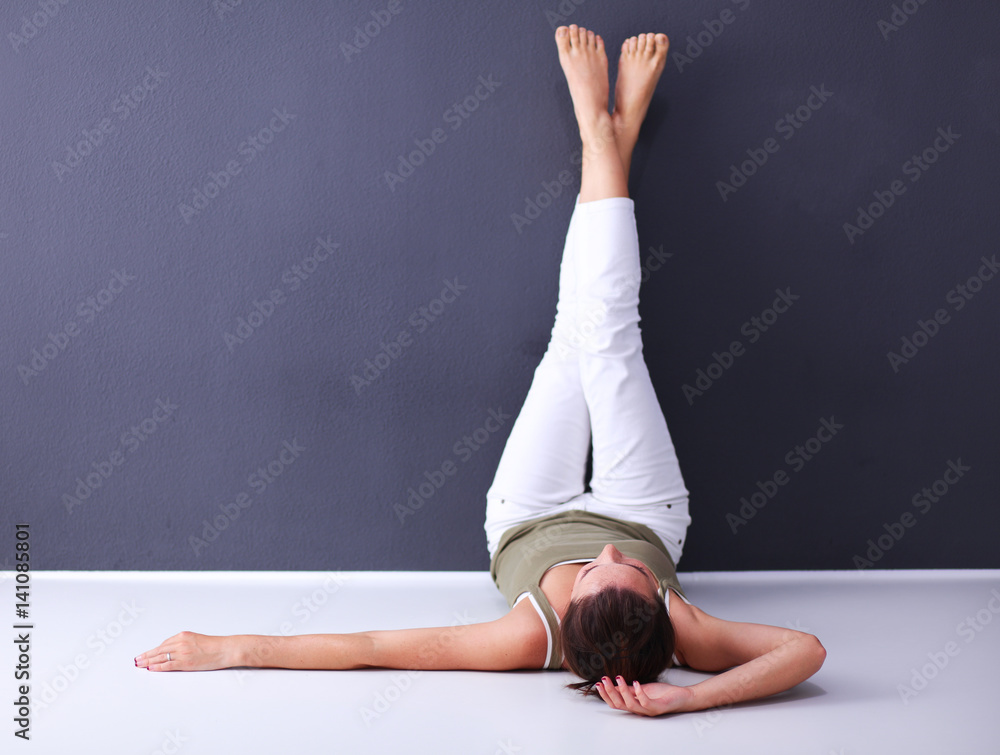 Young woman lying on the floor with legs up Stock Photo | Adobe Stock