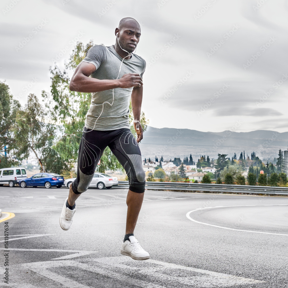 Black man running outdoors in urban road. Photos | Adobe Stock