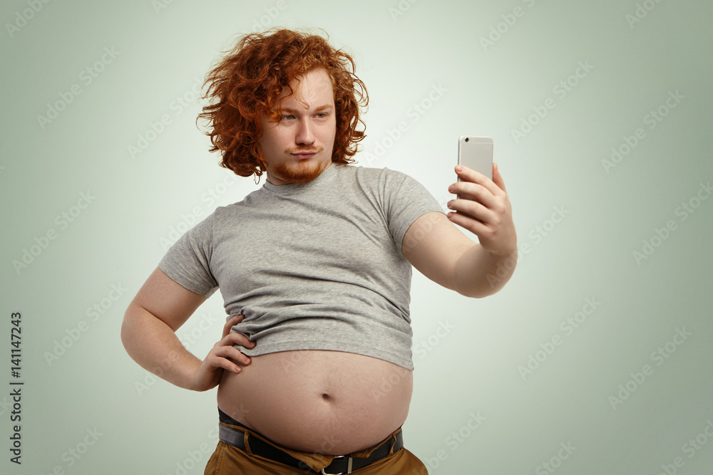 Funny overweight man with fat tummy hanging out of grey t-shirt ...