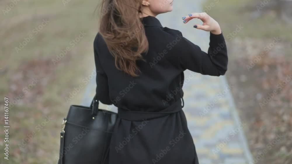 Wind Blows Long Dark Hair Of Beautiful Young Girl Walking Away From The