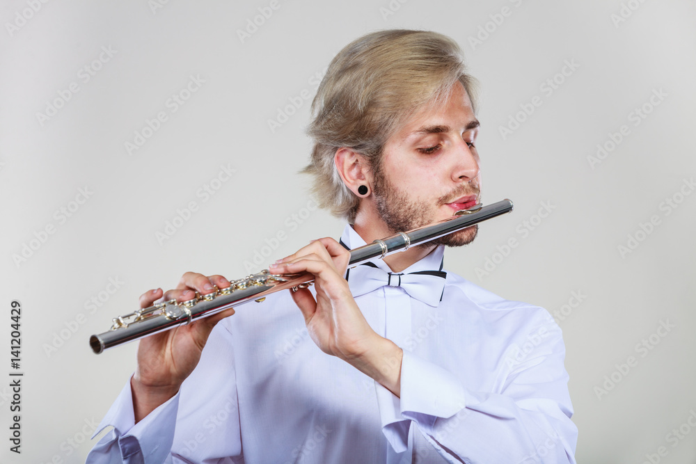 Male flutist playing his flute Stock Photo | Adobe Stock