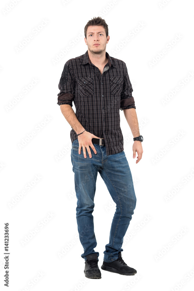Cool macho casual male model in jeans and plaid shirt looking at camera ...