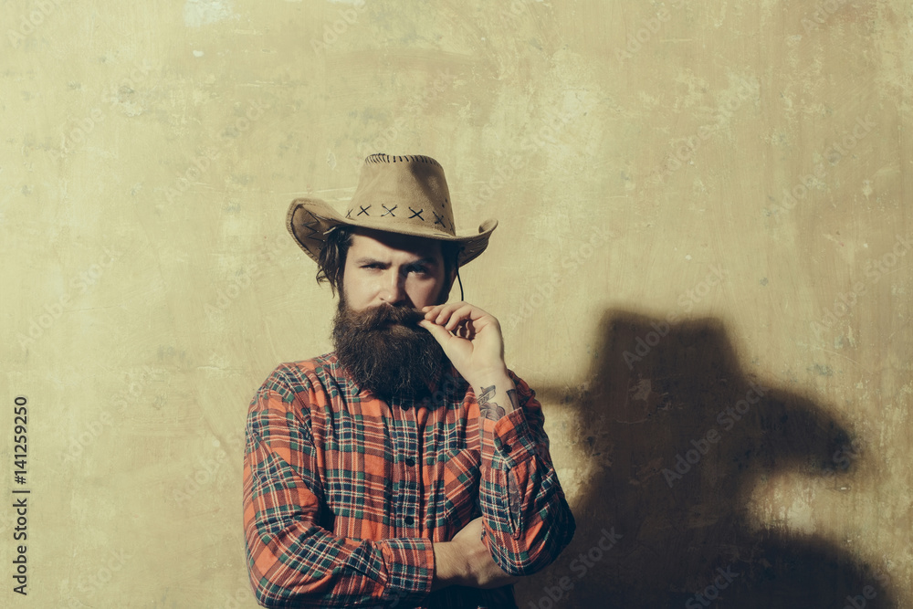 Bearded man in cowboy hat and black shadow on wall Stock Photo | Adobe ...