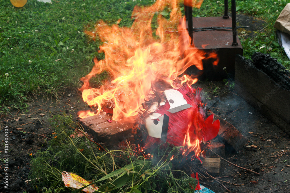 Celebration was over. The remains of pinata are dying in the fire ...