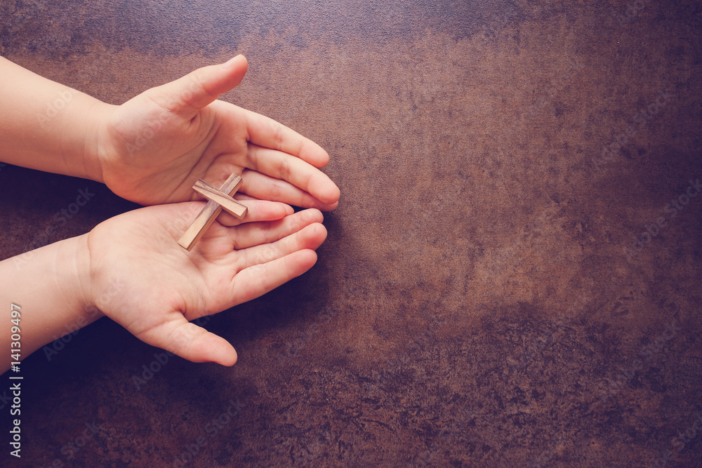 Wooden cross on praying children hands, worship, World Day of Prayer ...