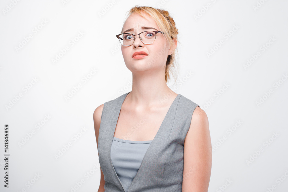 Young blonde woman looks shocked, stunned, taken aback and perplexed ...