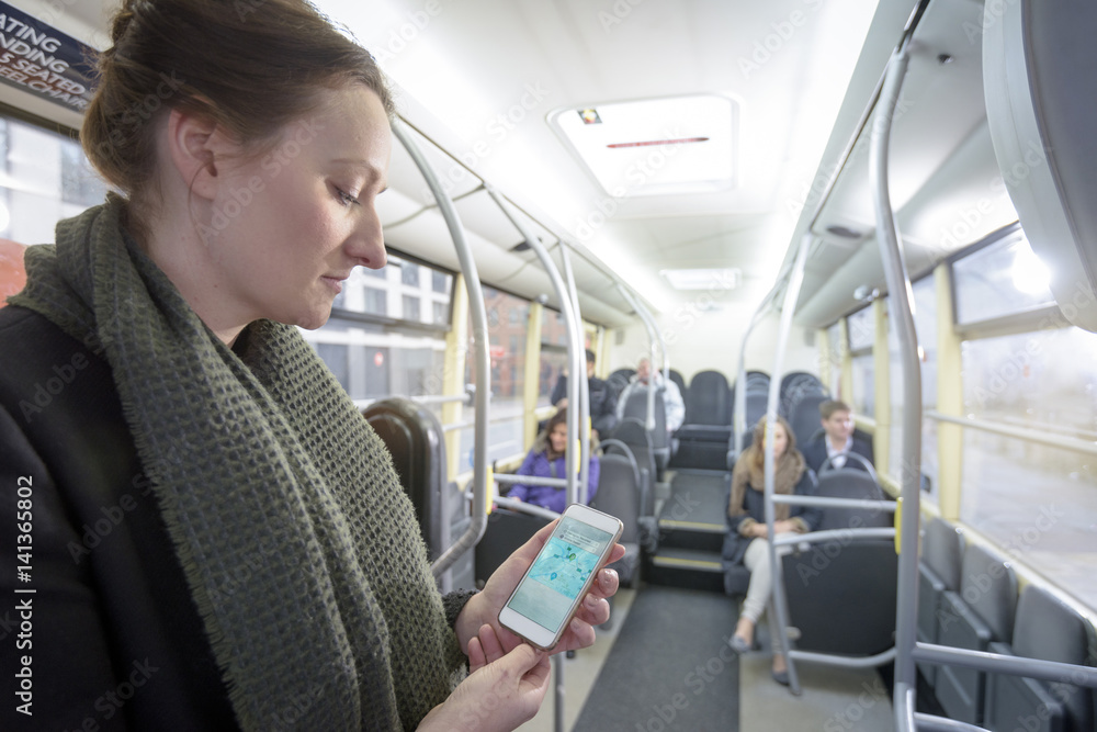 Passenger using smartphone to check map on electric bus Stock Photo ...