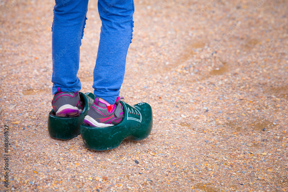 Little girl trying to wear a typical Dutch clog Stock Photo | Adobe Stock