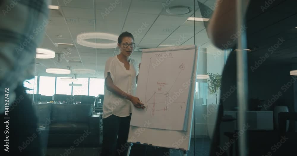 Businesswoman giving a presentation to coworkers in office. Female ...