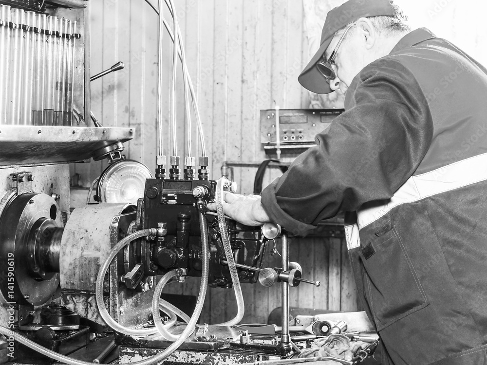 Professional mechanics testing diesel injector in his workshop, repair ...