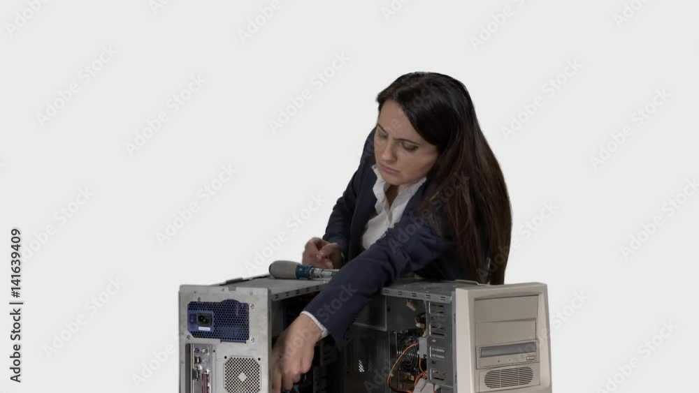 Frustrated woman office worker trying to repair computer system unit ...