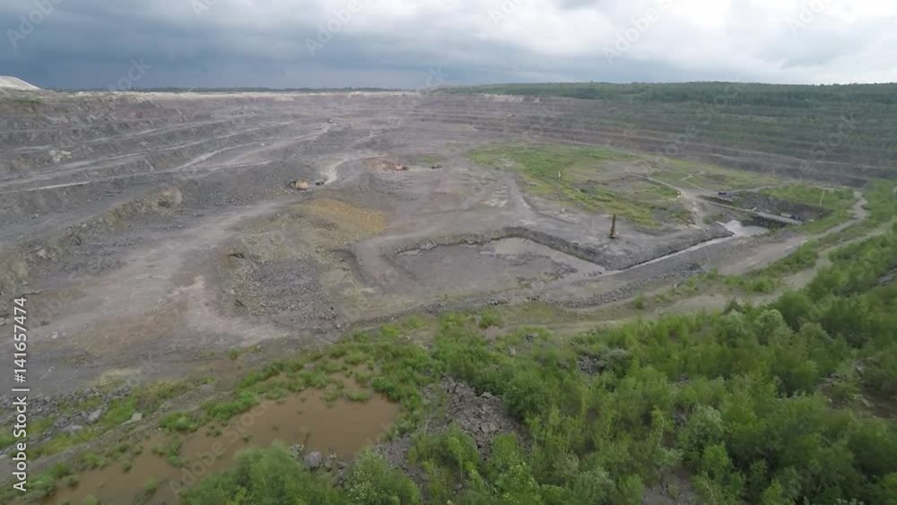 Video footage taken from a height over a giant quarry. Flight over a ...
