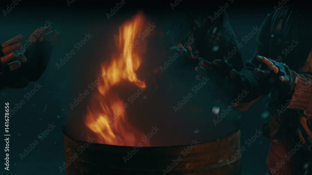 Vidéo Stock Homeless people warming near fire barrel. Warming hands on ...