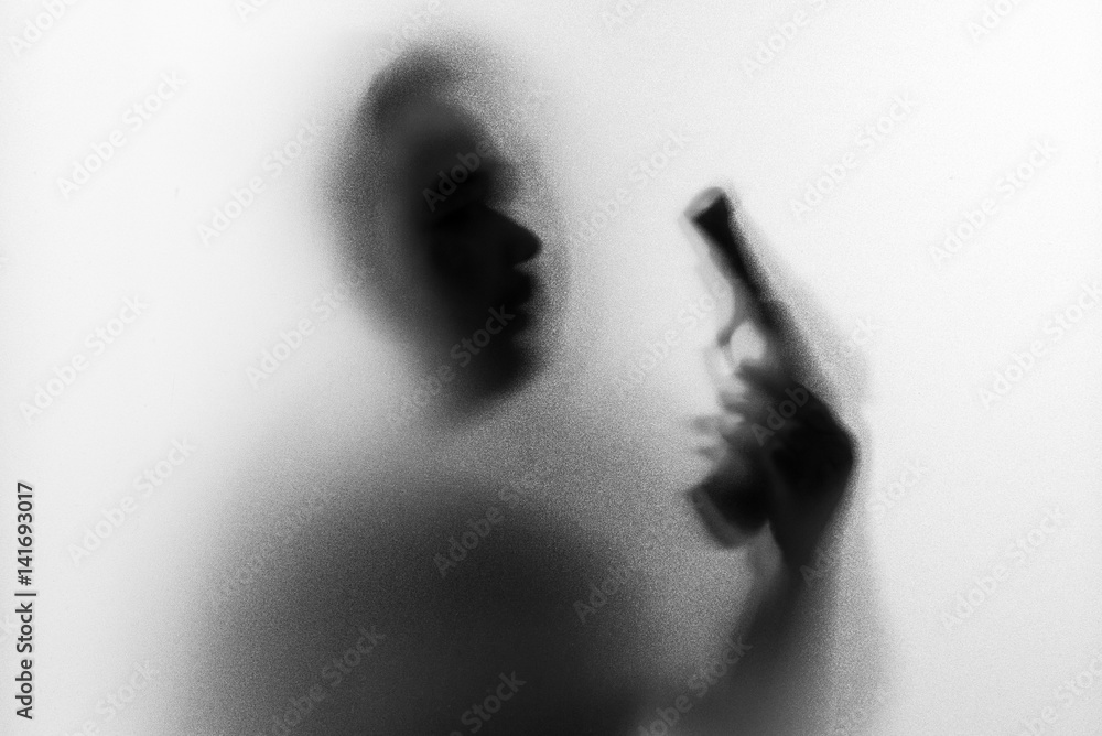 Shadow of horror man killer with a gun in his hand.Dangerous man behind ...