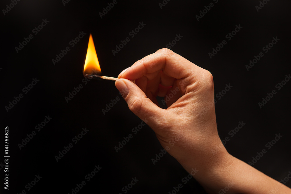 Woman hand holding lighted match, on black background. Stock Photo ...