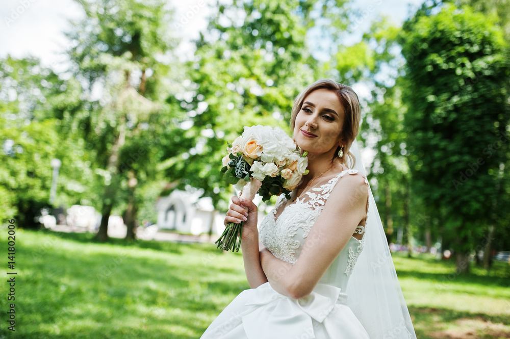 Cute blonde bride with wedding bouquet at park on sunny day. Stock ...
