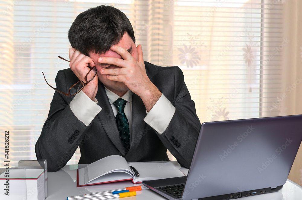 Sad man working on laptop in the office Stock Photo | Adobe Stock