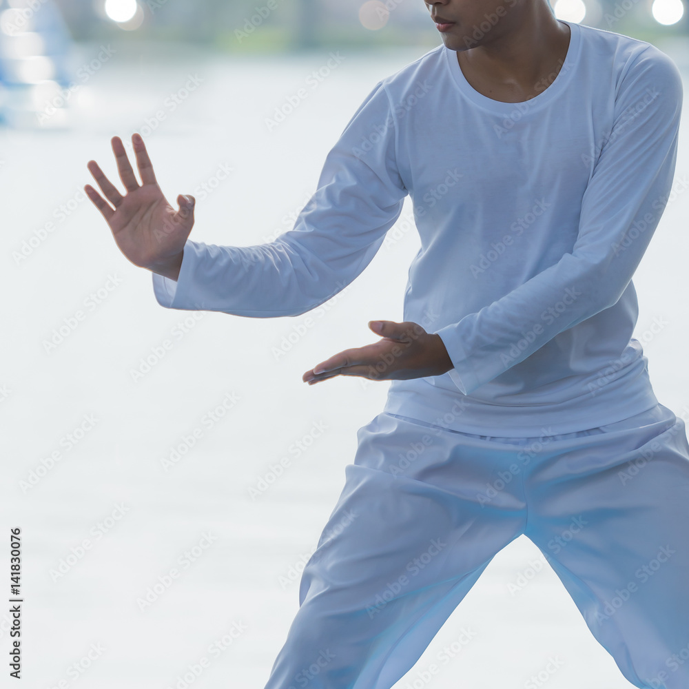 oung man practicing Tai Chi or Tai qi in the morning at the park for ...